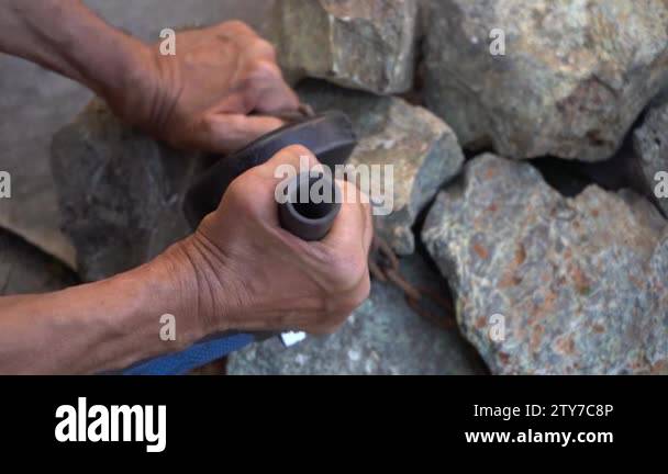 Cut the iron chain with a hand grinder. Work without gloves. The ...
