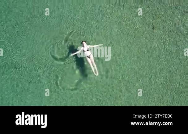 Woman enjoying vacation, floating in bikini on surface of sea in the ...