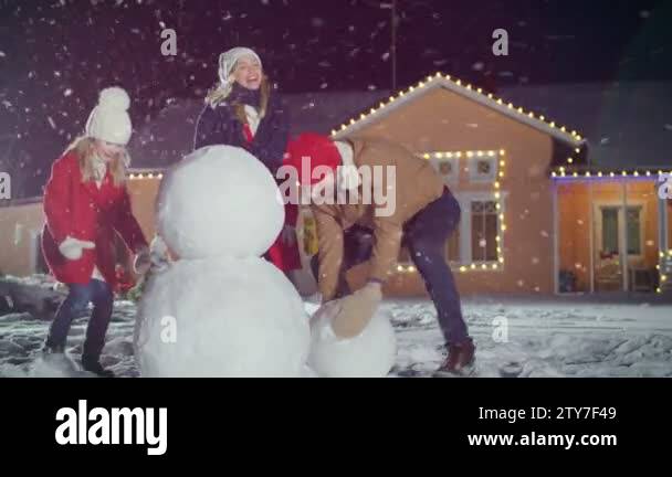 Happy Young Family Making Snowman in the Backyard of their Idyllic ...