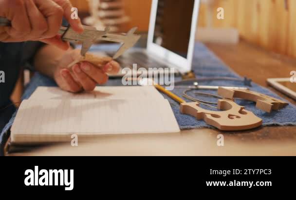 Side view close up of a senior Caucasian female luthier working at a ...