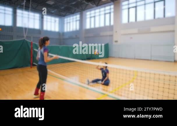 Sports for disabled people. A young woman sitting on the gym floor and ...