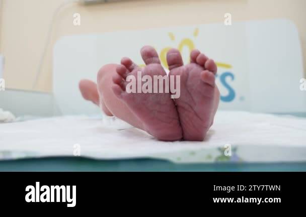 Newborn baby boy lying on back. Baby is kicking and stretching legs ...