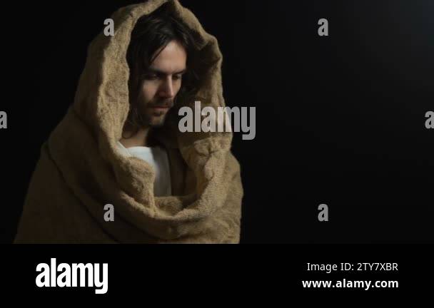 Jesus Christ reaching out his hand against dark background, helping ...