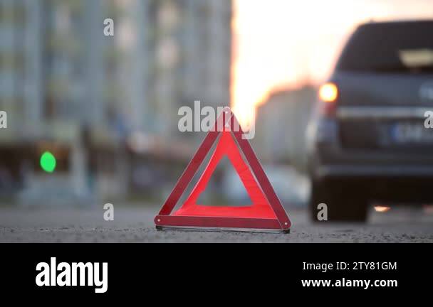 Red emergency stop sign behind broken blurred car with blinking lights ...