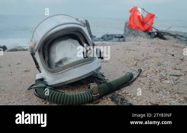 The head of a dead cosmonaut lies on the sand by the sea. Astronaut ...