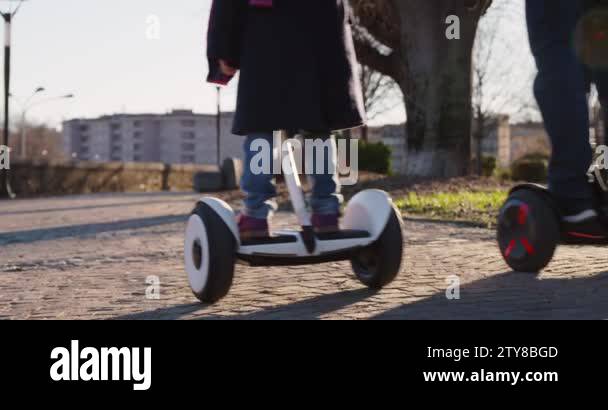 Daughter child girl riding segway with her dad in city.Modern future ...