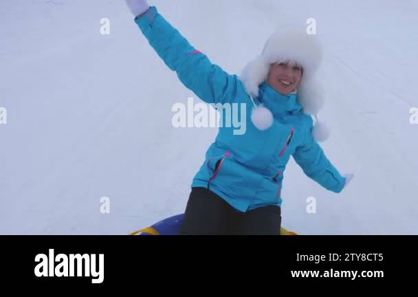 Happy girl slides through snow on sled. girl playing in park for the ...