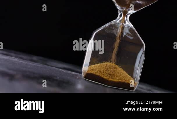 Sand moves through hourglass. Close up of hour glass clock. Old time ...