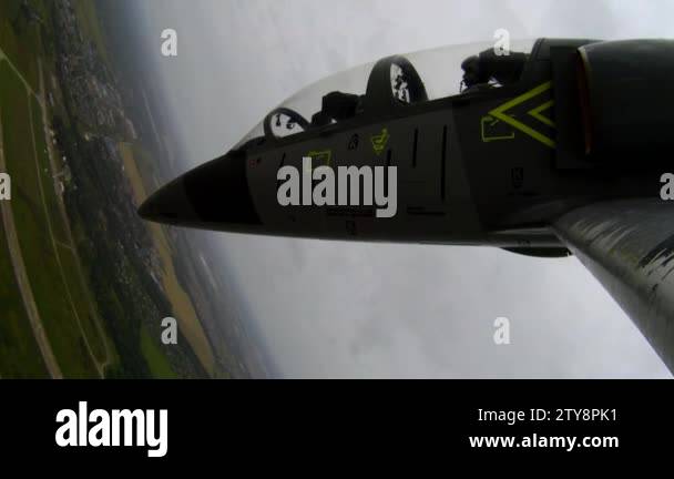 A combat gray blue fighter plane flies its nose down against a dark ...