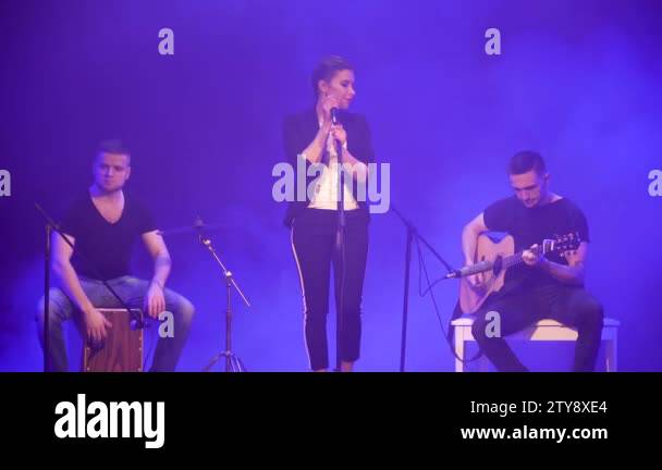 Music band performing on stage in blue concert light and smoke in ...