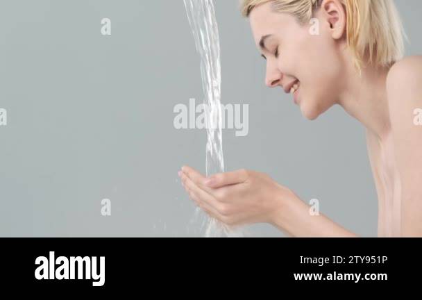 Woman washing her clean face with water. Young adult girl is washing ...