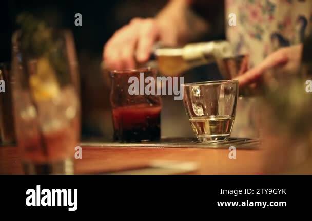 Bartender working. Mixing an alcoholic cocktail. Measuring amount of alcohol and adding an ...