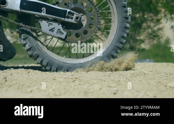 Wheel of motocross bike starting to spin and kicking up ground or dirt ...