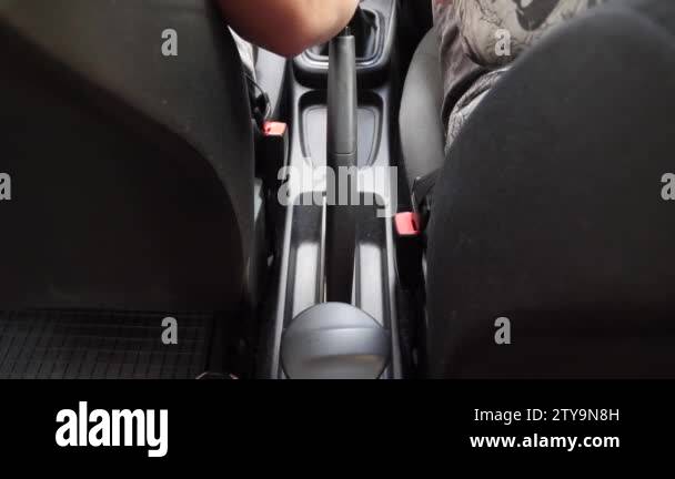 Man removes car from parking brake, inside car view. Person starts car ...