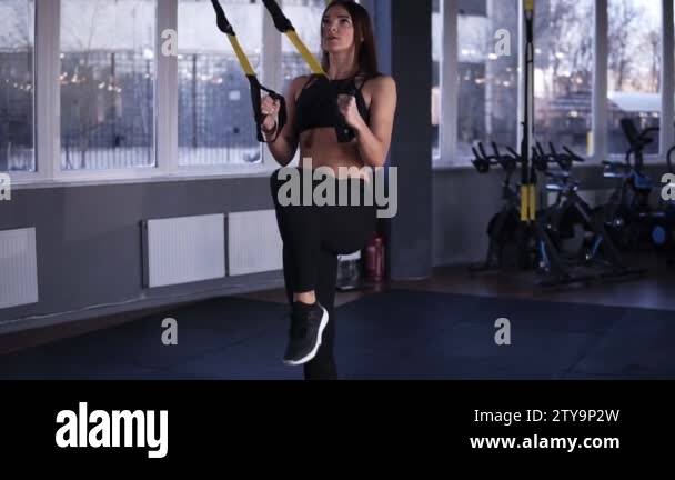 Muscular, fitness girl in black sportswear doing legs exercises while ...