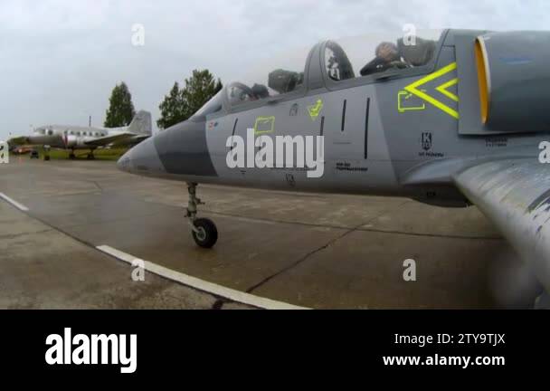 A gray and blue combat fighter plane move along on the runway between ...