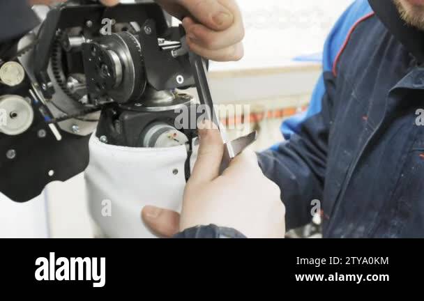 Two engineers make the mechanical arm of a robot. Prepare the item for ...