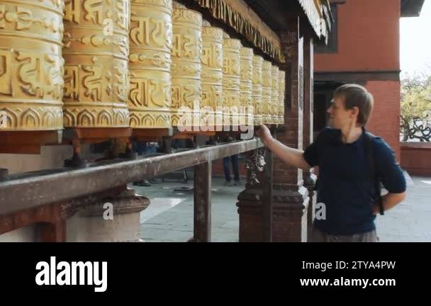 Buddhist prayer drums with close-up mantras.The female hand touches the ...