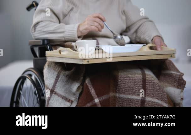 Handicapped lady reluctantly eating dinner in medical center ...