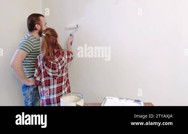 Handsome Father is Showing his Daughter how to Paint Walls. Happy ...