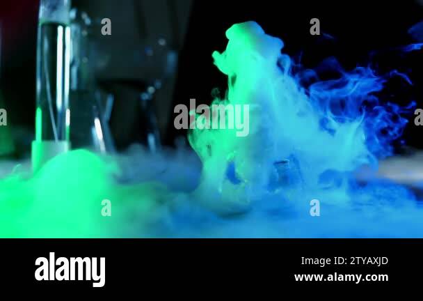 Flask with colorful liquid are steaming in neon light. Beautiful ...