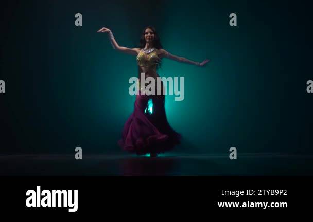 Belly dancer who is starting shaking her hips. Smoke background. Slow ...