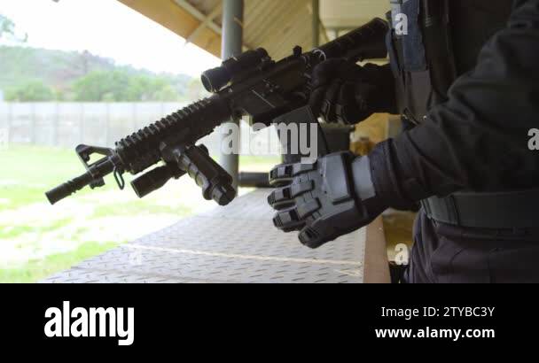 Mid section of young military soldier loading rifle magazine during ...