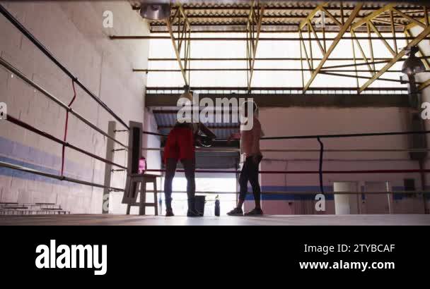 Rear view of a mixed race female boxing coach with short curly hair ...