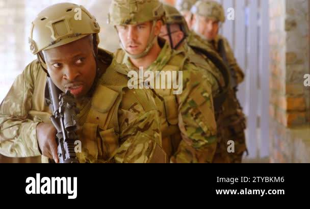 Front view of mixed-race military soldiers walking with rifles during ...