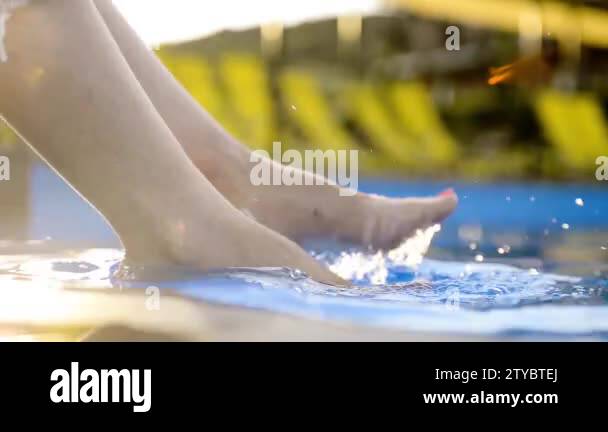 close-up footage of female feet splashing water in swimming pool Stock ...