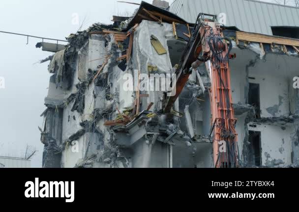 Excavator destroys the old building. Demolition work, pieces of ...
