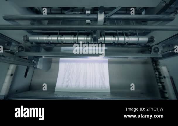 Paper pages with text are getting issued by a factory mechanism in a ...