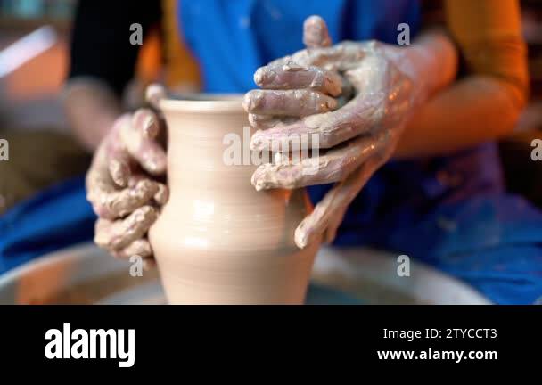 Hands of potter and his female student. Man and woman working together ...