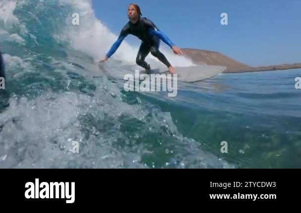 SLOW MOTION, UNDERWATER: Crystal clear ocean wave carved by pro male ...