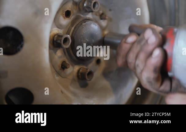 Installation of the machine wheel. Tightening the nut with a pneumatic ...