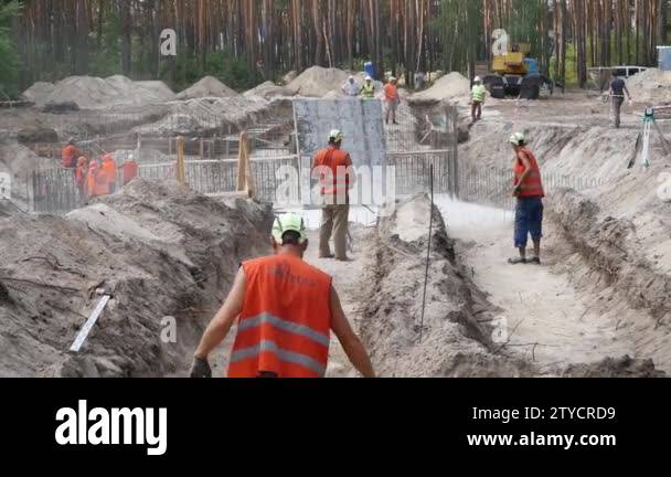 A rake worker measures the depth of the trench. Builders are digging a ...