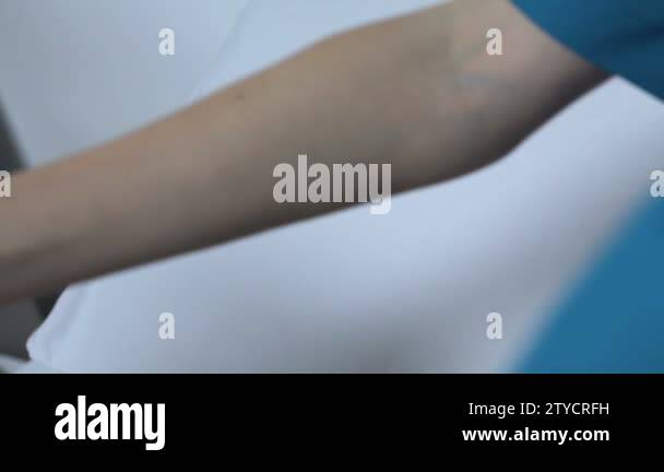 Nurse helping old woman to lay in hospital bed, lady feeling weak after ...