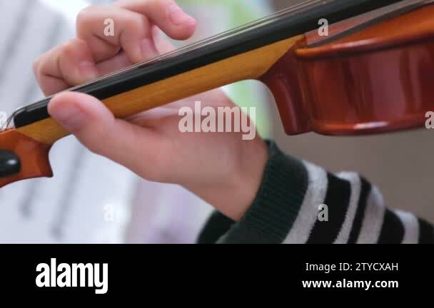 Violin in boys hands. Boy is learning to play violin. Correct setting ...