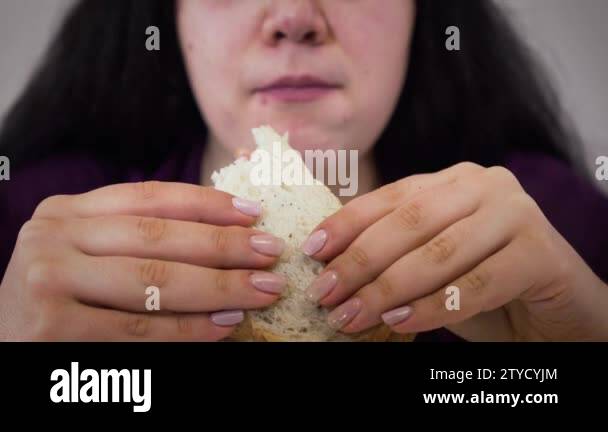 Extreme close-up of obese Caucasian brunette woman chewing sandwich ...