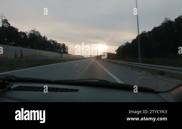 POV driving along a wide empty morning road early in the morning during ...