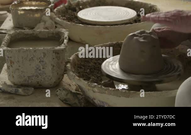 Potter craftsman starting to mold a new piece of clay in the lathe ...