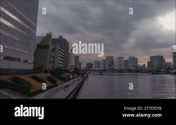 Gray rain clouds moving in fast time lapse dark sky over Tokyo city ...