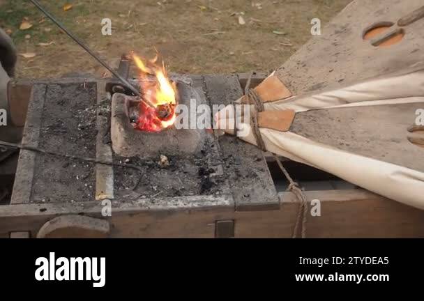 Blacksmiths working old fashioned bellows at the forge. The blacksmith ...