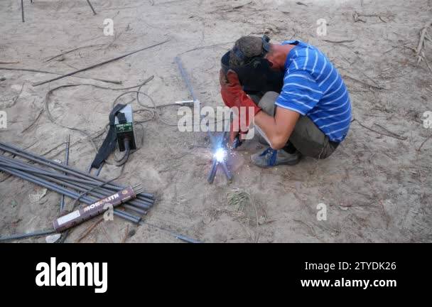 Welding of metal rods. The welder changes the electrode. The electrode ...