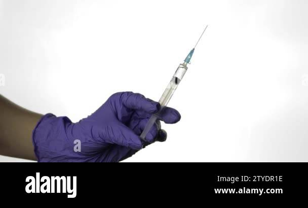 Doctors hands release excess air from the syringe, preparing for the ...