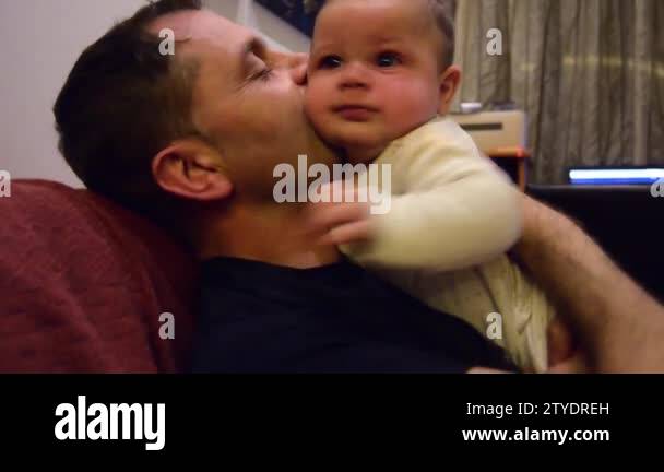 Confused six months old baby boy making funny face when daddy try to ...