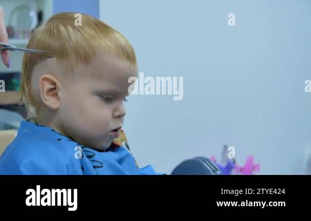 making haircut leveling hair with scissors for cute little child 2 year ...