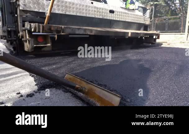 Tarmac Laying Machine at a Road Construction Site - Slow Motion. Worker ...