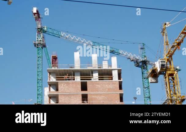 crane lifting heavy blocks at building construction site. reat estate ...