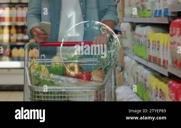Digital composite of an adult man pushing cart at the grocery and ...